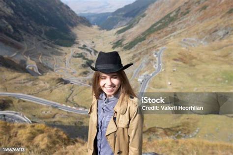 검은 모자를 쓴 아름다운 소녀는 산의 배경에 눈을 감고 웃는다 20 24세에 대한 스톡 사진 및 기타 이미지 20 24세 가을 검은색 Istock