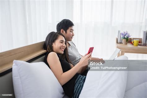 아시아 커플 온라인 쇼핑 과 지불 신용 카드 에 노트북 컴퓨터 행복한 커플 에 홈 서핑 그물 에 침대 가정 생활에 대한 스톡