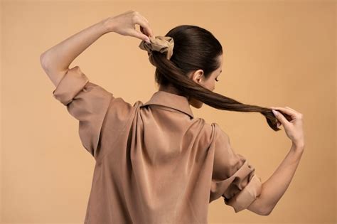 Free Photo Woman Tying Her Hair Medium Shot