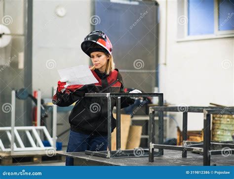 Beautiful Blonde Woman Works As A Welder In Workshop Reading