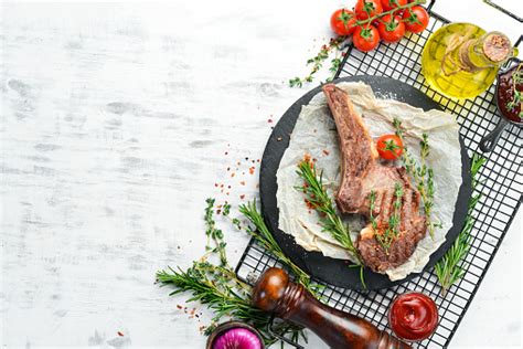 흰 나무 배경에 향신료와 야채와 뼈에 구운 쇠고기 스테이크 플랫 레이 맨 위 보기입니다 굽기에 대한 스톡 사진 및 기타 이미지