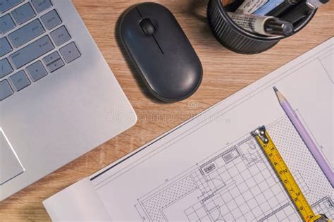 Top View Of An Architect S Work Desk With Building Layouts Stationery Pencil Laptop Mouse