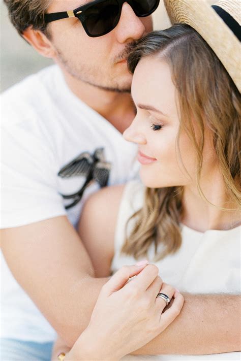 Premium Photo Man Hugging And Kissing The Head Of A Woman In A Straw Hat