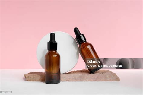호박색 유리 점적기 화장품 병 흰색 연단 자연 스킨 케어 Spa 뷰티 제품 디자인 분홍색 배경에 미네랄 유기농 오일 모형 기름진