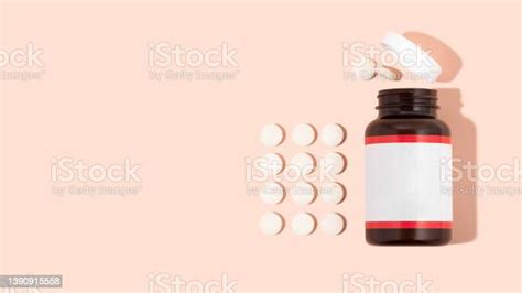 장미 분홍색 배경에 알약과 유리 병에 담긴 흰색 비타민 몇 가지 정제 건강한 면역 개념 구성 웰빙 라이프 스타일 위쪽 보기