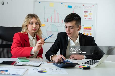 사무실에서 종이 차트와 노트북을 함께 사용하는 두 명의 재무 분석가 2명에 대한 스톡 사진 및 기타 이미지 2명 30 34세 경영자 Istock