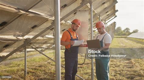 태양 에너지 설치시 패널을 검사하는 태블릿 기술자 태양 광 농장 에너지에서 태양 전지 패널을 확인하는 에너지 기술자 스마트 엔지니어 설치 태양 전지 2명에 대한 스톡 사진