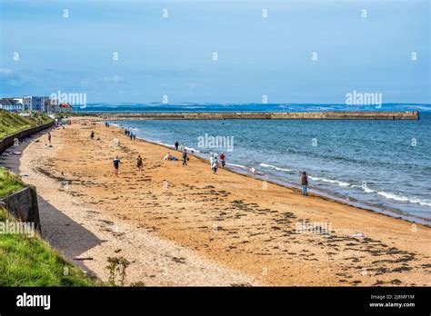 Holidaymakers Enjoying The Sunshine On East Sands Beach In The Royal