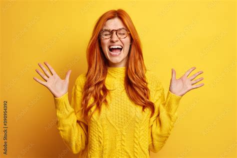 Overjoyed Redhead Woman Laughs Out Loudly Keeps Palms Raised Bursts