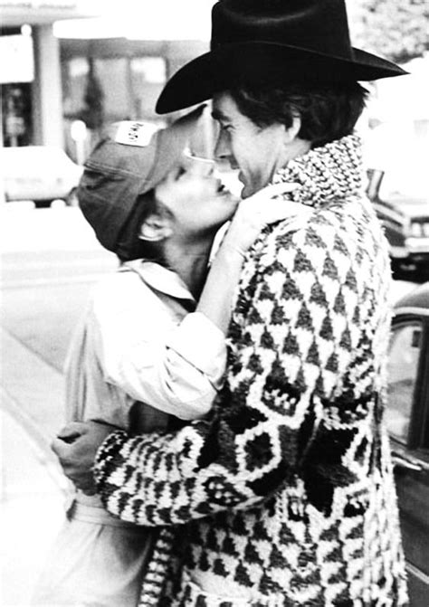 An Old Photo Of Two People Kissing Each Other On The Street In Front Of
