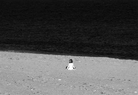 Premium Photo Rear View Of Girl Sitting On Shore At Beach