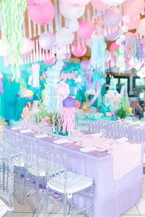 An Under The Sea Themed Birthday Party With Pink Blue And Green Decorations On Tables