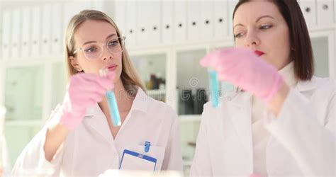 Female Chemists In Gloves Compare Glass Tubes With Liquid Stock Video Video Of Gloves Uniform