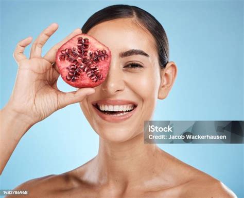 아름다움 피부 관리 및 피부과 및 화장품을 위한 석류 과일 얼굴을 가진 여성 초상화 파란 배경에 천연 제품 얼굴 빛 영양 건강한