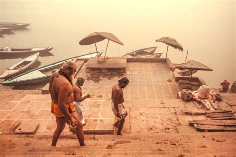Three Naked Hindu Men Walking For Religious Service Past Riverbanks Of Holy Ganga River At