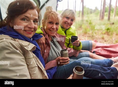 Portrait Of Smiling Senior Women Having Tea Together While Sitting In