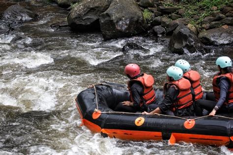 Un Grupo De Personas En Una Balsa Están En Un Río Con Una Balsa Negra