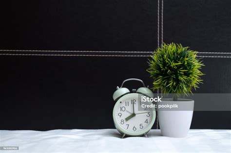 빈티지 알람 시계와 침실에서 집에서 침대에 흰색 꽃병에 작은 장식 나무 일어나 거 나 침대 시간 개념 0명에 대한 스톡 사진 및