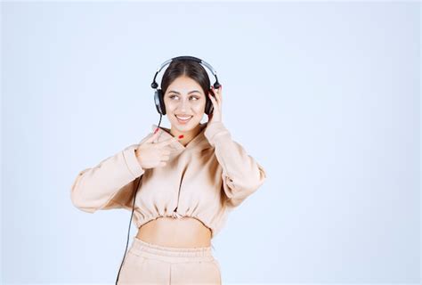 Mujer joven usando audífonos y escuchando su lista de reproducción con disfrute Foto Gratis