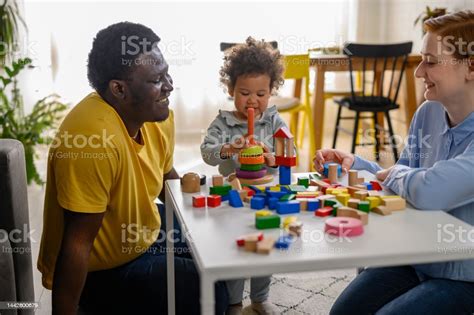 집에서 화려한 교훈적인 나무 장난감을 가지고 노는 귀여운 딸을 지원하는 어머니와 아버지 건축하기에 대한 스톡 사진 및 기타 이미지 건축하기 다민족 그룹 아이 Istock