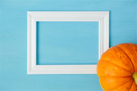 파란색 나무 배경 추수 감사절과 할로윈 개념에 사진 흰색 프레임 오렌지 호박 위에서 볼 수 있습니다 맨 위 보기 텍스트 및 디자인을 위한 공간 복사 가을에 대한 스톡 사진