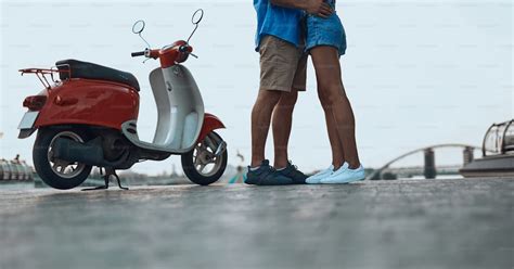 거리에서 현대 오토바이입니다 반바지와 운동화를 입은 젊은 남녀가 근처에 서 있다 사진 Unsplash의 오토바이 이미지