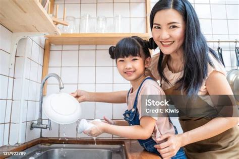 아시아 행복 한 가족 부엌에서 집에 숙박 어머니는 함께 작은 아이 딸과 함께 시간을 보내고 지원 사랑하는 엄마는 집에서 설거지 젊은 유치원 소녀를 가르칩니다 육아 관계 개념