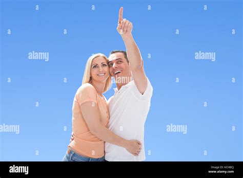 Woman Looking At Man Pointing On Sky Outdoors Stock Photo Alamy