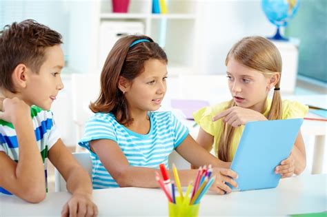 Menina Que Fala A Seu Colega De Classe Foto Grátis