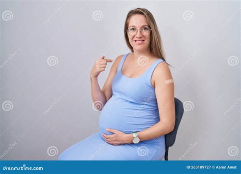 Young Pregnant Woman Wearing Band Aid For Vaccine Injection Pointing