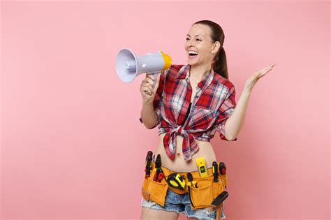 젊은 흥분 핸디 여자 격자 무늬 셔츠 데님 반바지 키트 도구 벨트 핑크 배경에 고립 된 다양 한 악기 보류 확성기 비명의 전체 여성 남성 작업을 하 고입니다 혁신 개념입니다