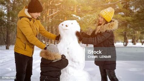 행복한 가족 엄마 아빠와 아들이 겨울 도시 공원에서 눈사람을 만들고 있습니다 눈사람에 대한 스톡 사진 및 기타 이미지 눈사람