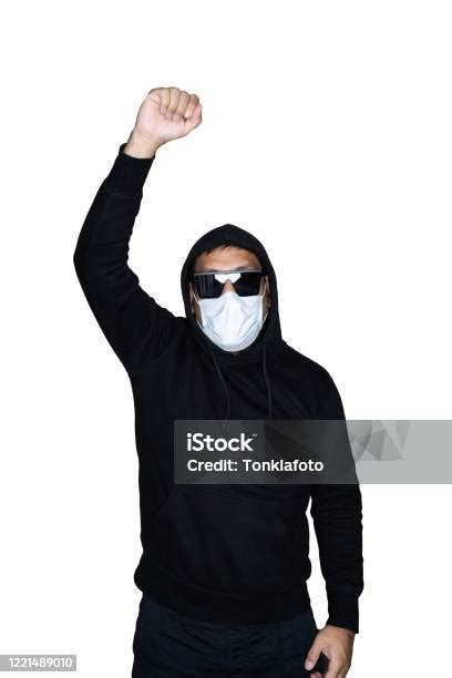 의료 마스크와 검은 후드를 입고 수염 아시아 남자는 흰색 배경에 주먹을 제기 심각한 느낌 항의 관심 요청의 개념 텍스트 또는 복사 공간에 배치합니다 클리핑 경로 뉴질랜드에