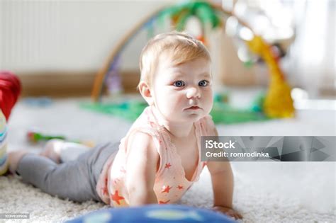 작은 귀여운 아기 소녀를 크롤링할 학습 화려한 장난감 키즈 룸에 크롤 링 하는 건강 한 아이 아기 다리의 다시 보기입니다 귀여운 유아 집 발견 하 고 다른 기술을 학습