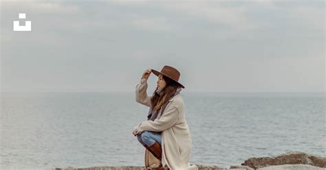 바위에 앉아 바다를 바라보는 여자 사진 Unsplash의 무료 의류 이미지