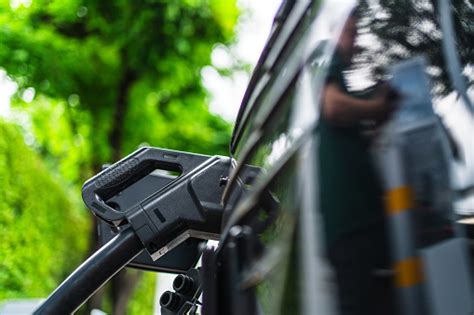 Ev 충전기가 자동차에 연결된 전기차 충전소 지속 가능하고 깨끗한 에너지 개념으로 자연 환경에서 친환경 교통과 친환경 모빌리티를