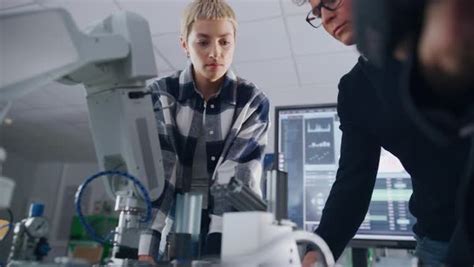 Students Gathering Around Bionic Robot Arm With Female Teacher And