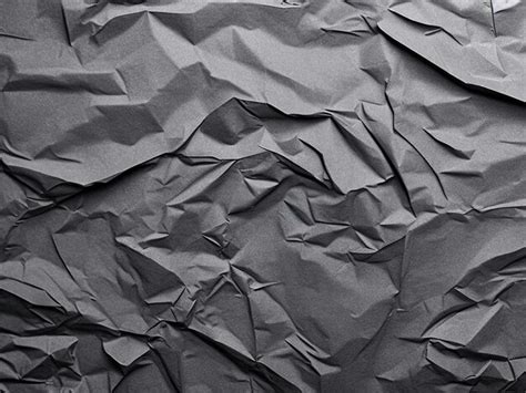 黒のしわくちゃの紙の背景 しわくちゃの紙のテクスチャ プレミアム写真