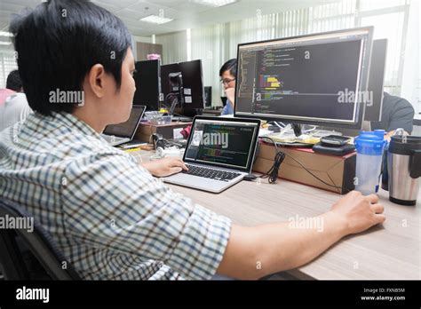 Asian Outsource Software Developer Looking Screen Sitting At Desk Stock
