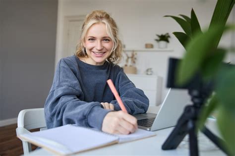 Free Photo Cute Smiling Girl Sits In A Room Writes Down Notes Doing