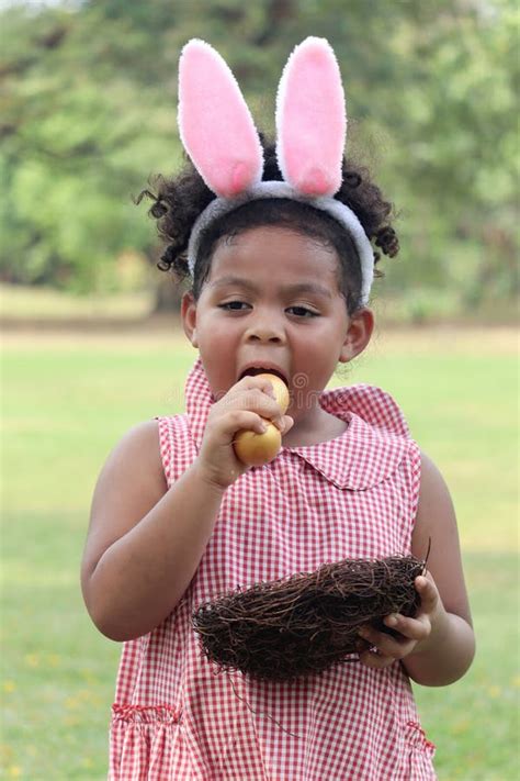 Cute African Girl With Black Curly Hair Wears Pink Bunny Ears Holds