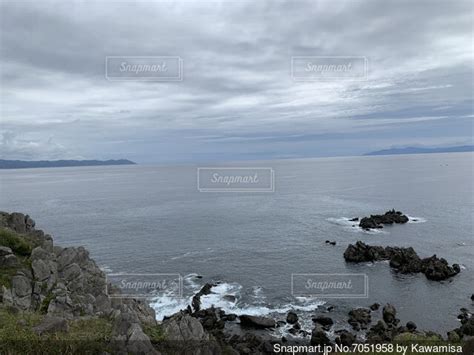 水域の隣の岩だらけの海岸にいる人々のグループの写真・画像素材 7051958 Snapmart（スナップマート）