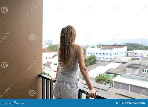 Young Blonde Girl Wearing Summer Pajamas Standing On Balcony And