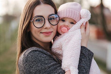 어머니와 그녀의 작은 아기 소녀의 초상화입니다 아름 다운 엄마와 귀여운 아기 어머니는 그녀의 딸을 Hud 아기는 Peanch 컬러 모자와 젖꼭지 장난감을 입고 가족에 대한