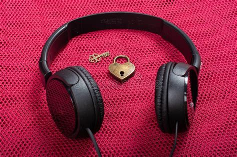 Closeup Of Big Black Headphones On A Pink Surface Under The Lights