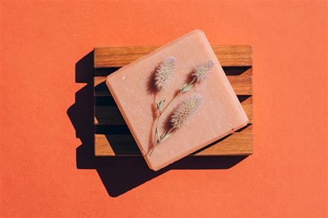 붉은 갈색 배경 위에 나무 비누 접시에 향기로운 허브가 있는 수제 비건 비누 바 집에서 천연 성분으로 허브 비누 만들기 평면도 플랫 레이 스타일 비누 접시에 대한 스톡 사진