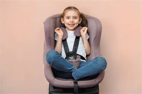 Cute Smiling Preschool Caucasian Girl Strapped In Car Seat Looking At