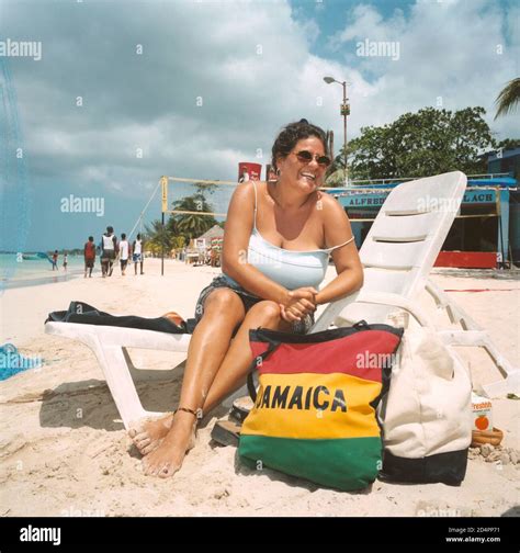 A White Woman With Brown Hair Sat On A Sunbed At Negril Beach Jamaica