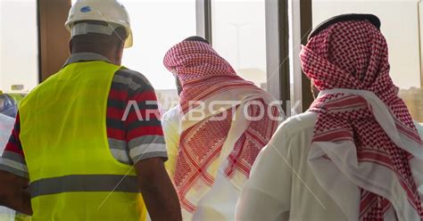 صورة من الخلف لرجلان عربيان خليجيان سعوديان يرتديان الزي السعودي