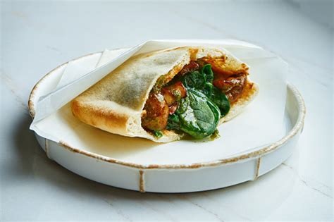 맛있는 길거리 음식 대리석 배경에 흰색 세라믹 접시에 양피지에 후무스와 버섯 시금치와 토마토피타 그리스 요리 클로즈업 0명에